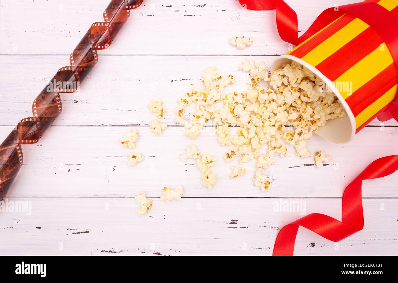 Popcorn, red ribbon on white wooden background. Valentine's day, movie ...