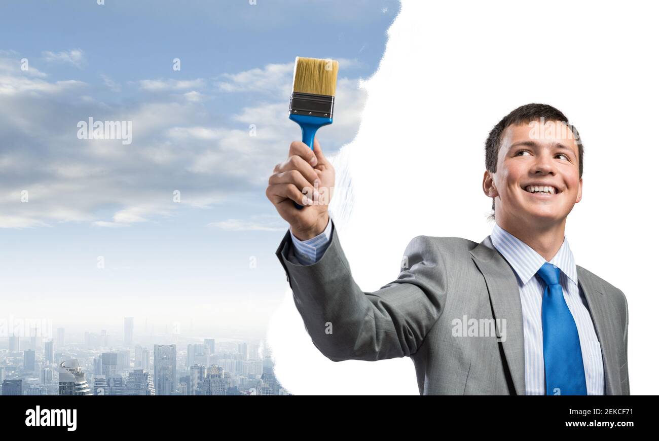Creative businessman painter holding paintbrush Stock Photo - Alamy