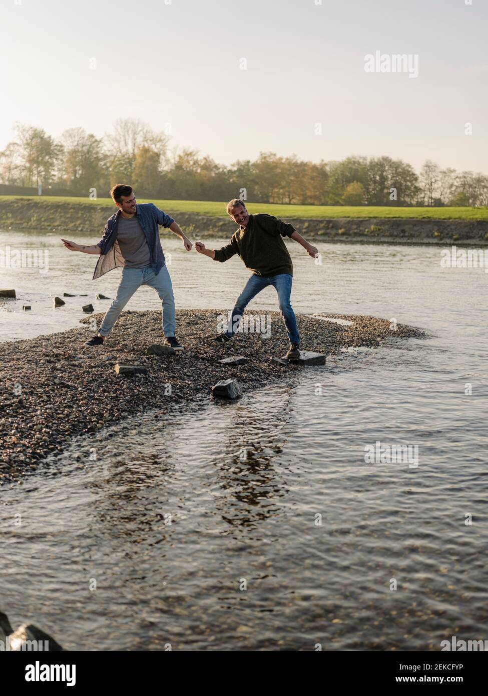 Father and son throwing pebbles in river during autumn Stock Photo - Alamy