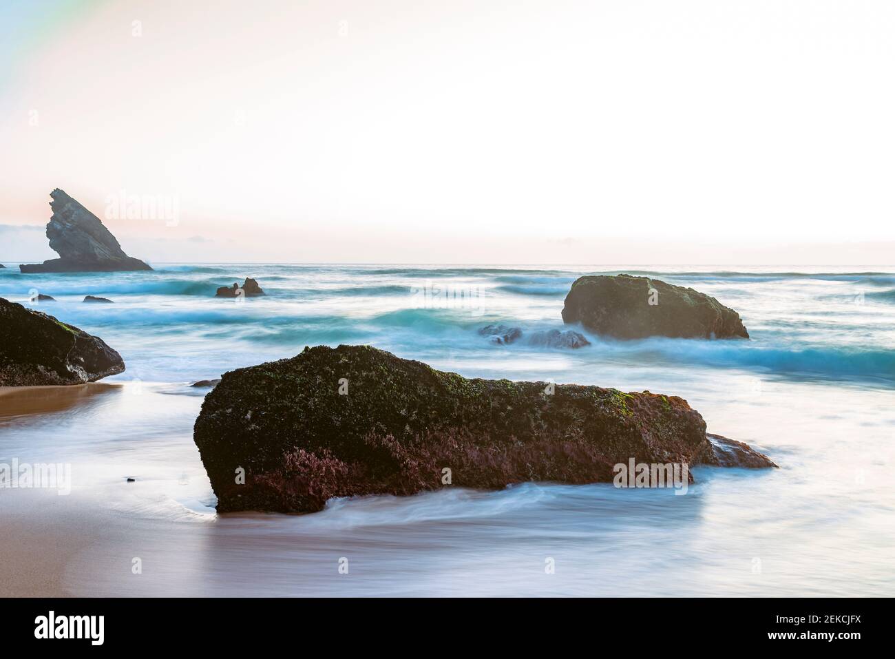 Beach with rocks at sunset Stock Photo - Alamy
