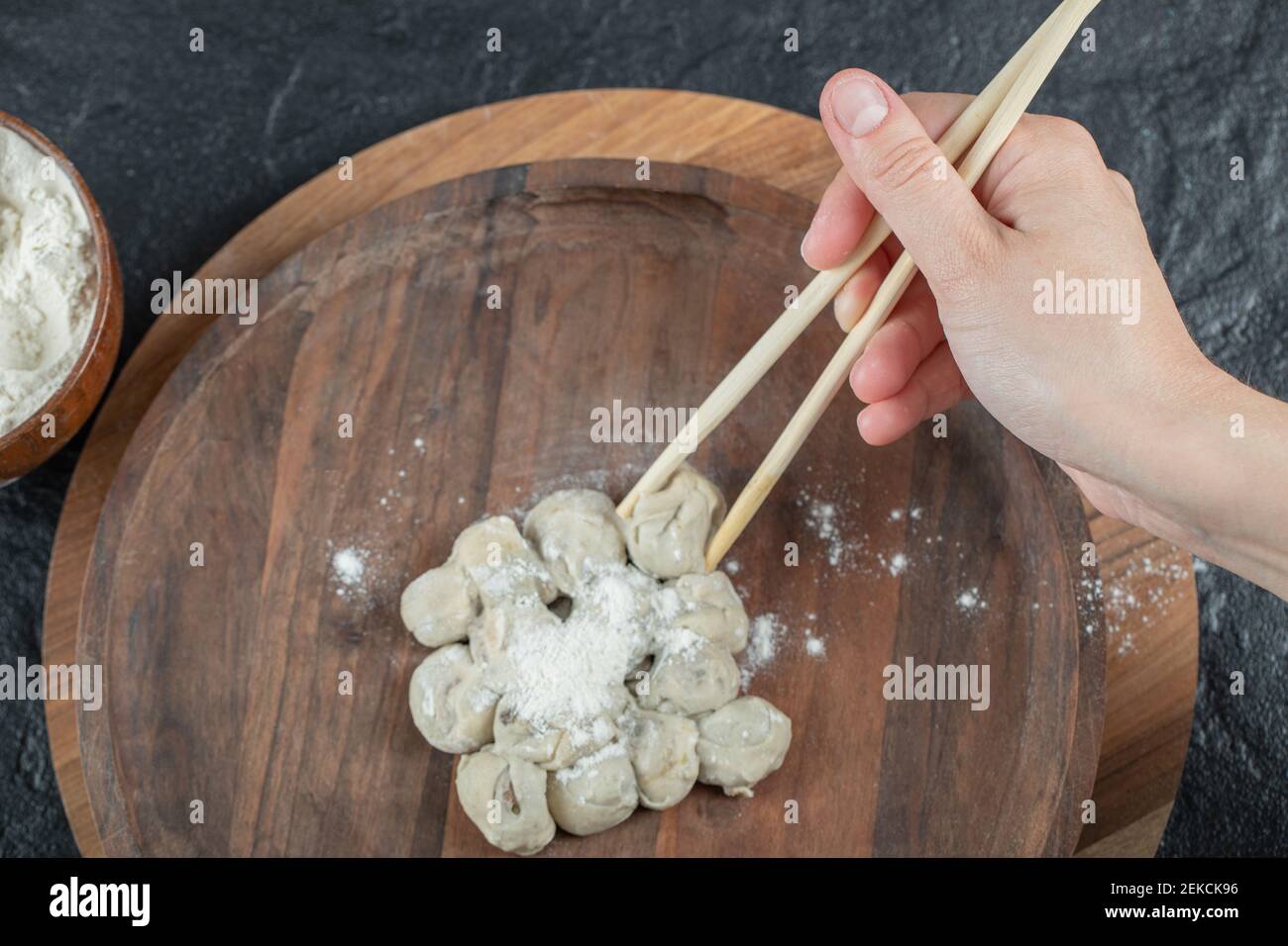 Hand holding a chopstick with a dumpling Stock Photo - Alamy