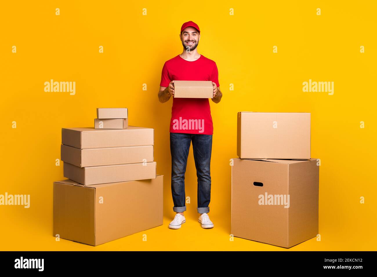 Full length body size photo of smiling courier keeping carton box for ...