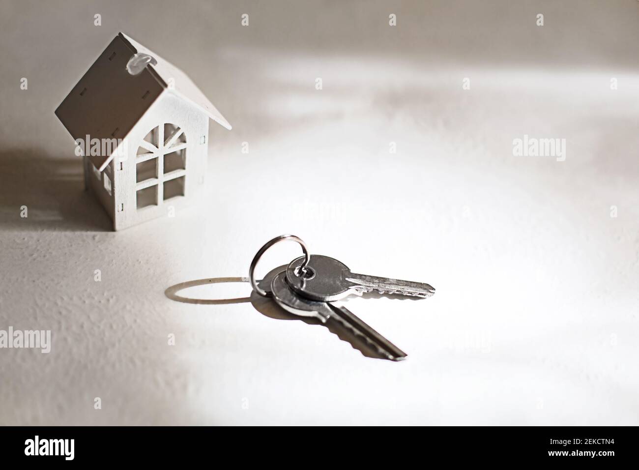 White wooden house symbol and keys on a gray background. Cottage ...