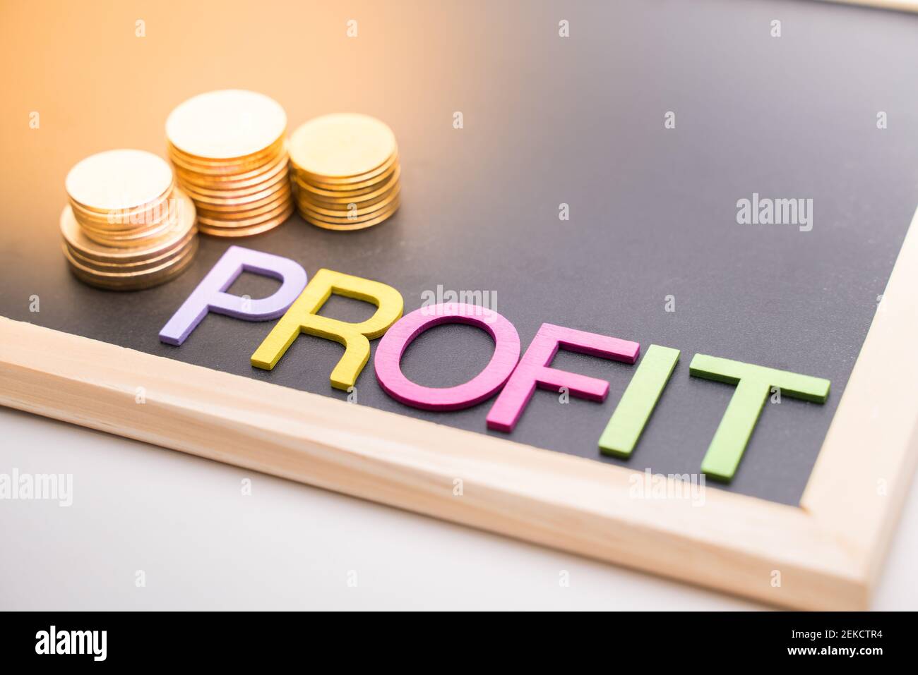 Profit text on blackboard with coin and light Stock Photo - Alamy