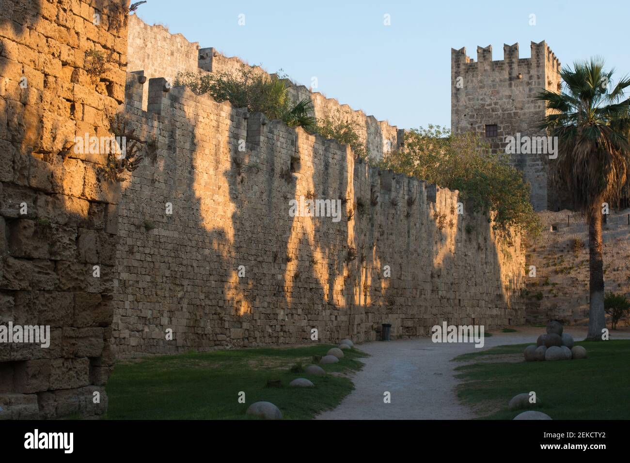 Rhodes town fortifications: old stone tower and palmtree at sunset ...