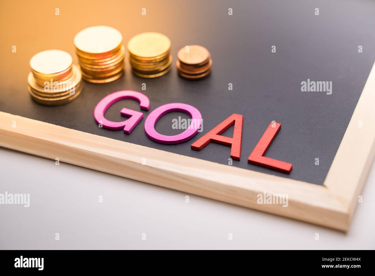 Goal text on blackboard with coin and light Stock Photo - Alamy