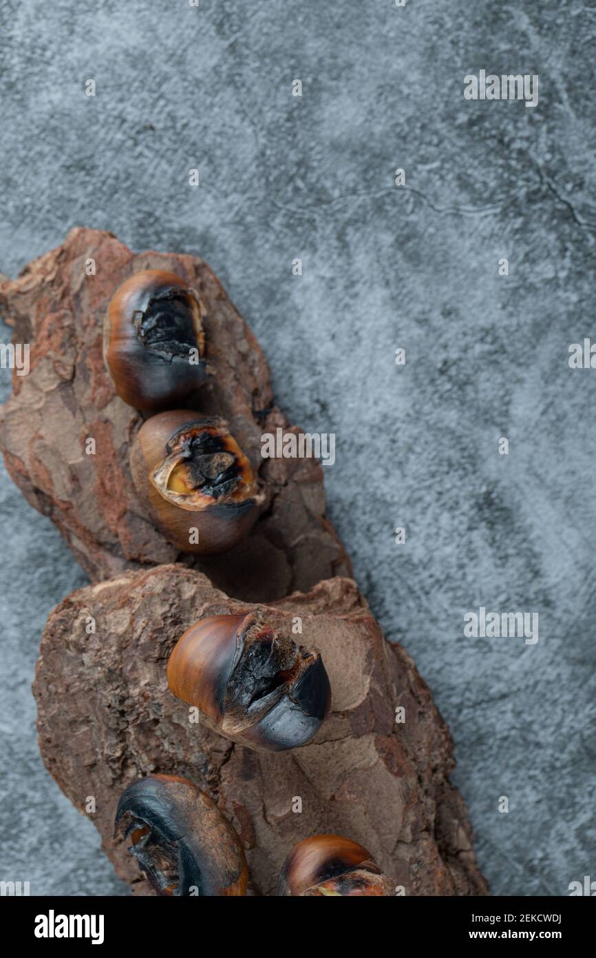 Delicious fried chestnuts on a tree bark Stock Photo - Alamy