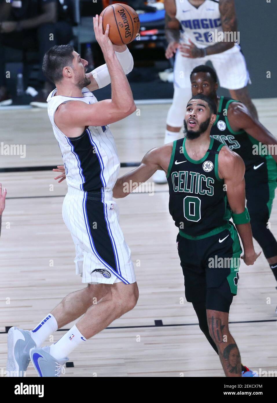 Orlando Magic center Nikola Vucevic (left) shoots over Boston Celtics ...