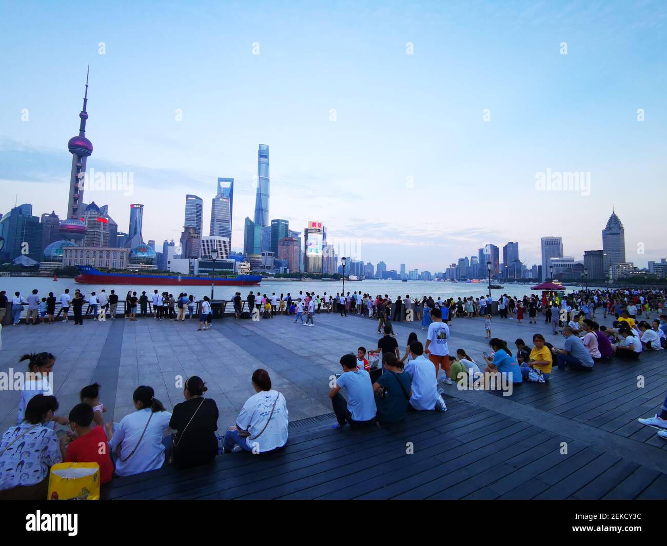 A group of tourists sit on the steps at sunset, as the temperature was ...