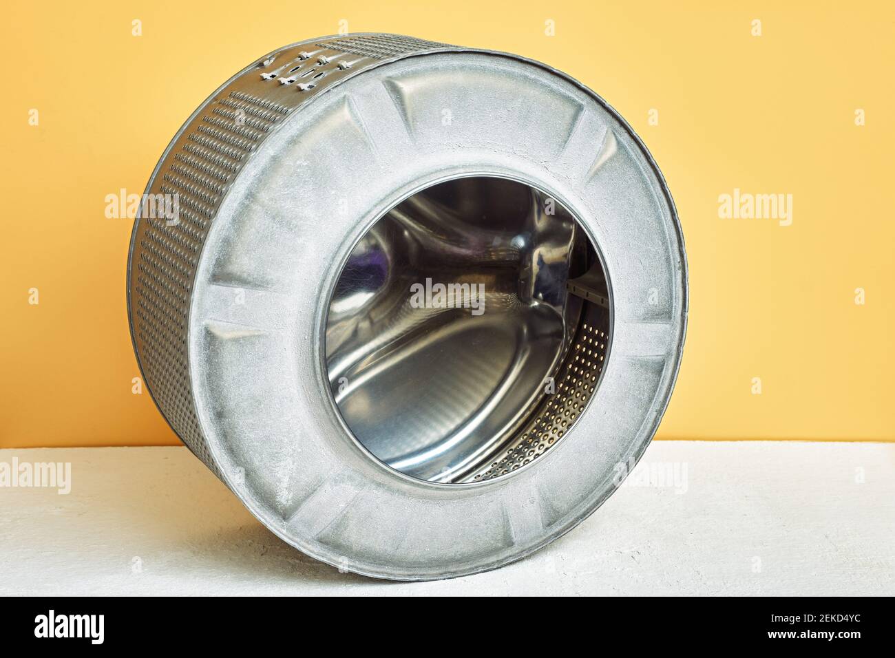 Metal drum washing machine. repairs clothes washer. Yellow background ...