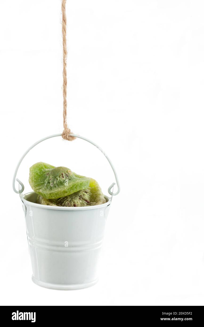 A full bucket of kiwi fruits dry hanging from a rope. White background ...