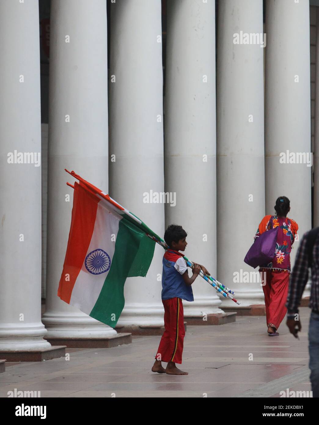 A boy sells Tricolour flags on the eve of Independence Day at Connaught ...