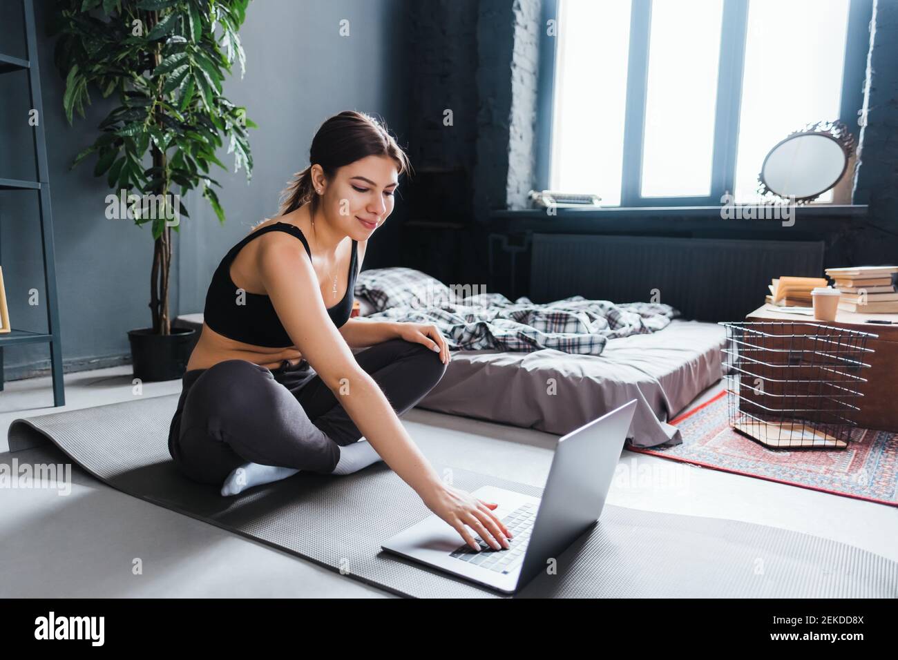 Beautiful brunette fitness woman make stretching exercises in front ...