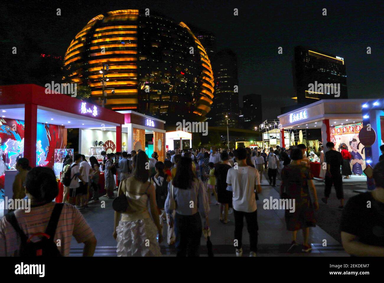 People walk around and shop at the "2020 Amazing Night in Hangzhou", a ...