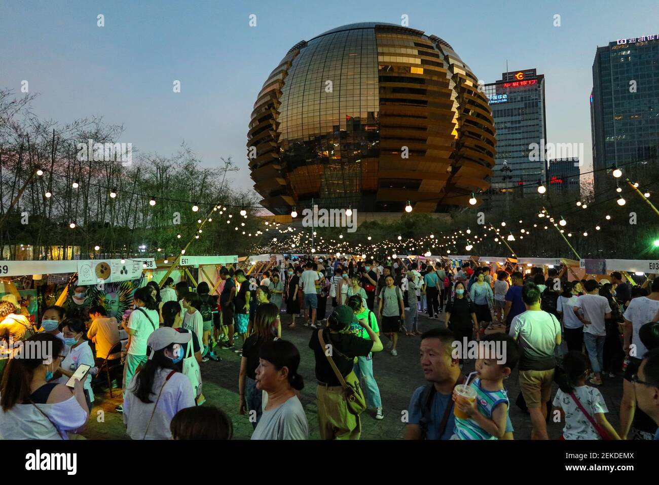 People walk around and shop at the "2020 Amazing Night in Hangzhou", a ...