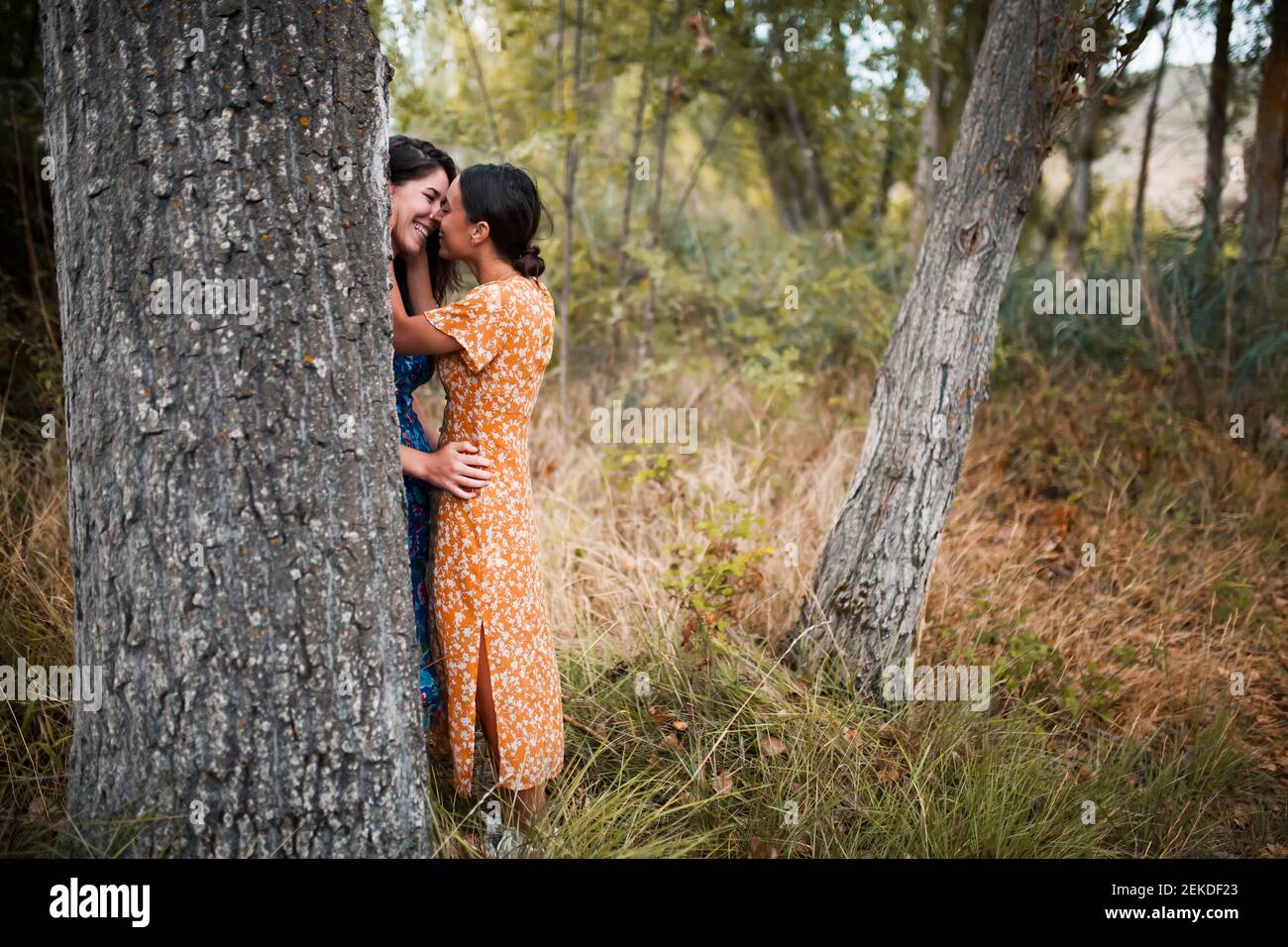 Two young lesbians kissing and caressing each other in the woods Stock Photo - Alamy