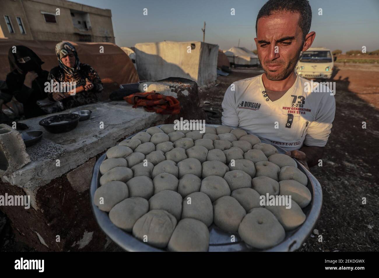 A Syrian man seen showing bread in the Zardana refugee camp in Syria ...