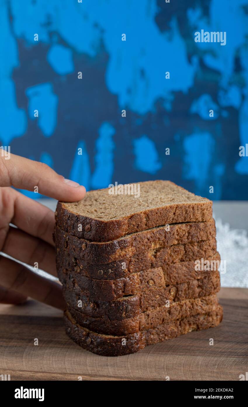 Hand holding a slices of brown bread Stock Photo - Alamy