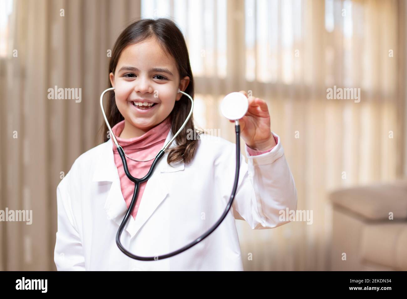 Portrait of smiling little child dressed as a doctor with stethoscope ...