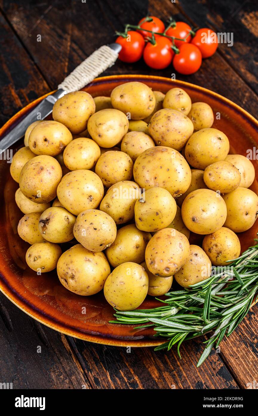 Raw baby mini Potatoes. Dark wooden background. Top view Stock Photo ...