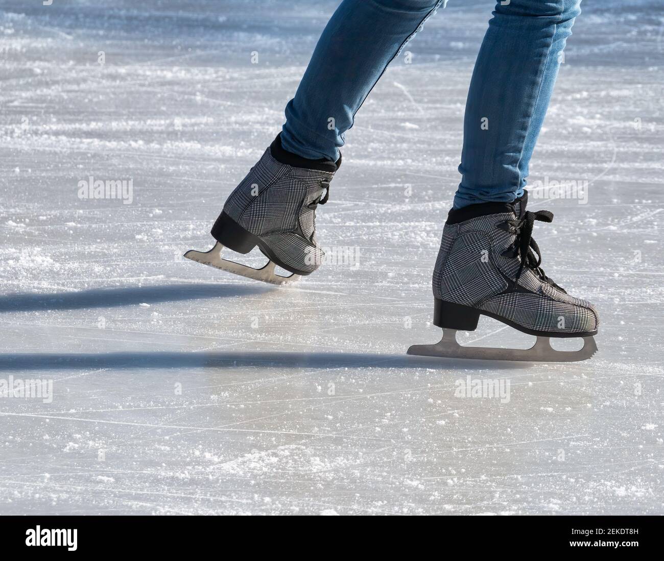Close up with the legs of a woman with skates on ice. Ice skating ...