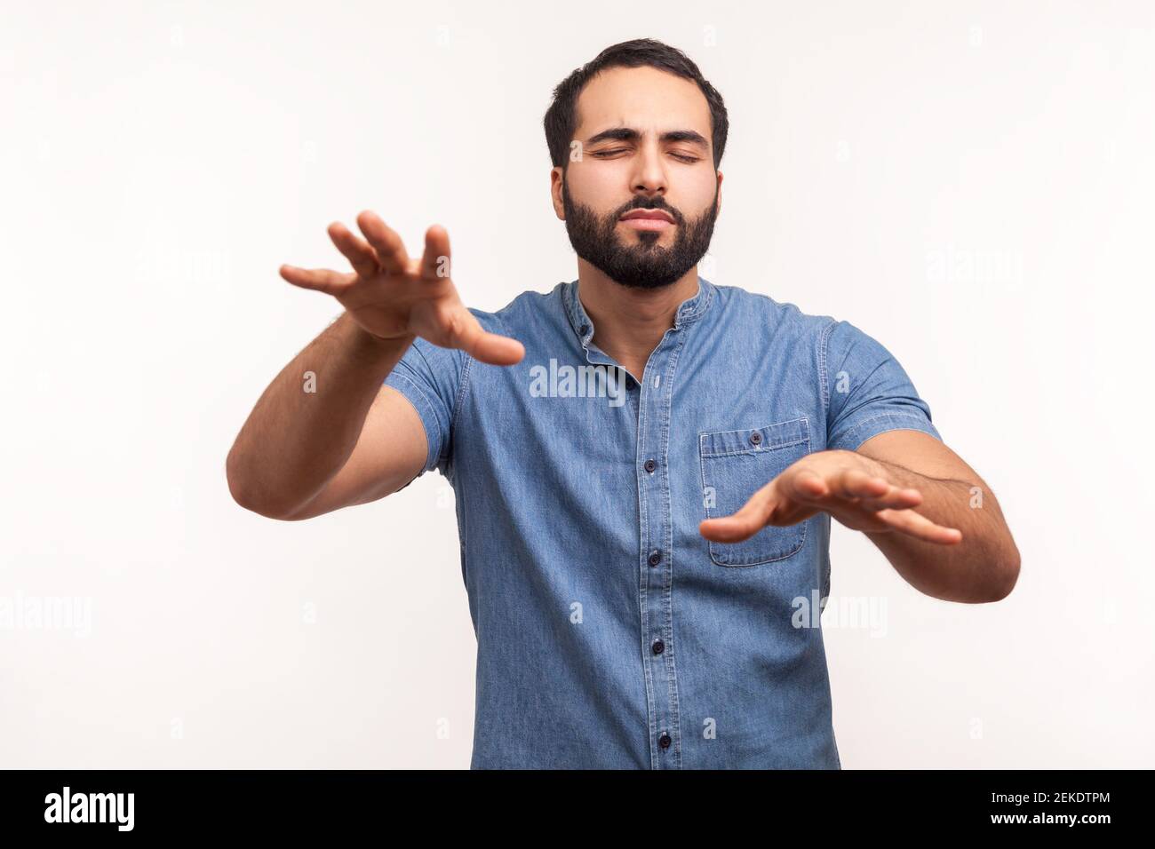 Disoriented bearded man moving with closed eyes, touching space with ...