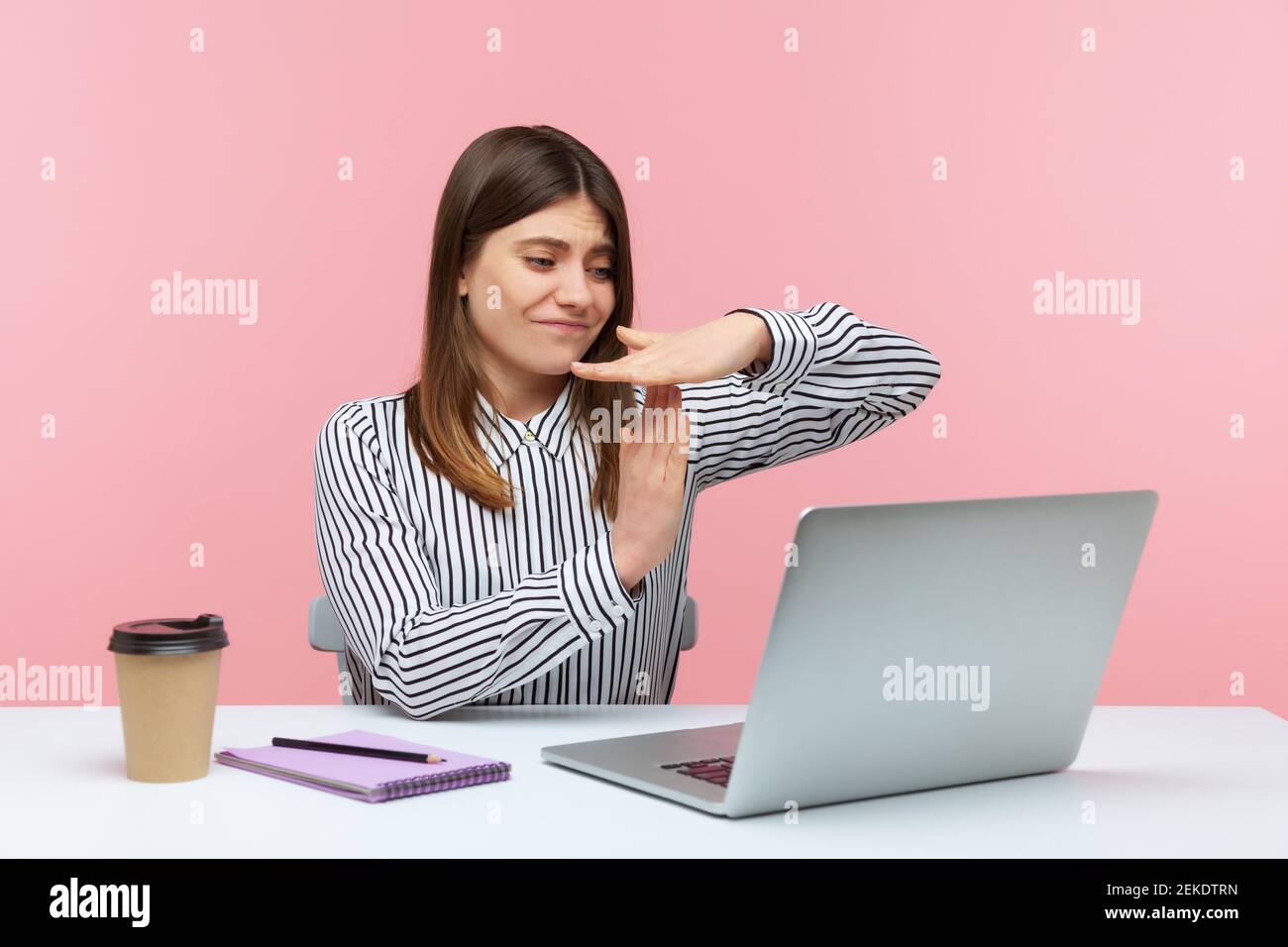 Tired woman office worker showing time out gesture looking at laptop ...
