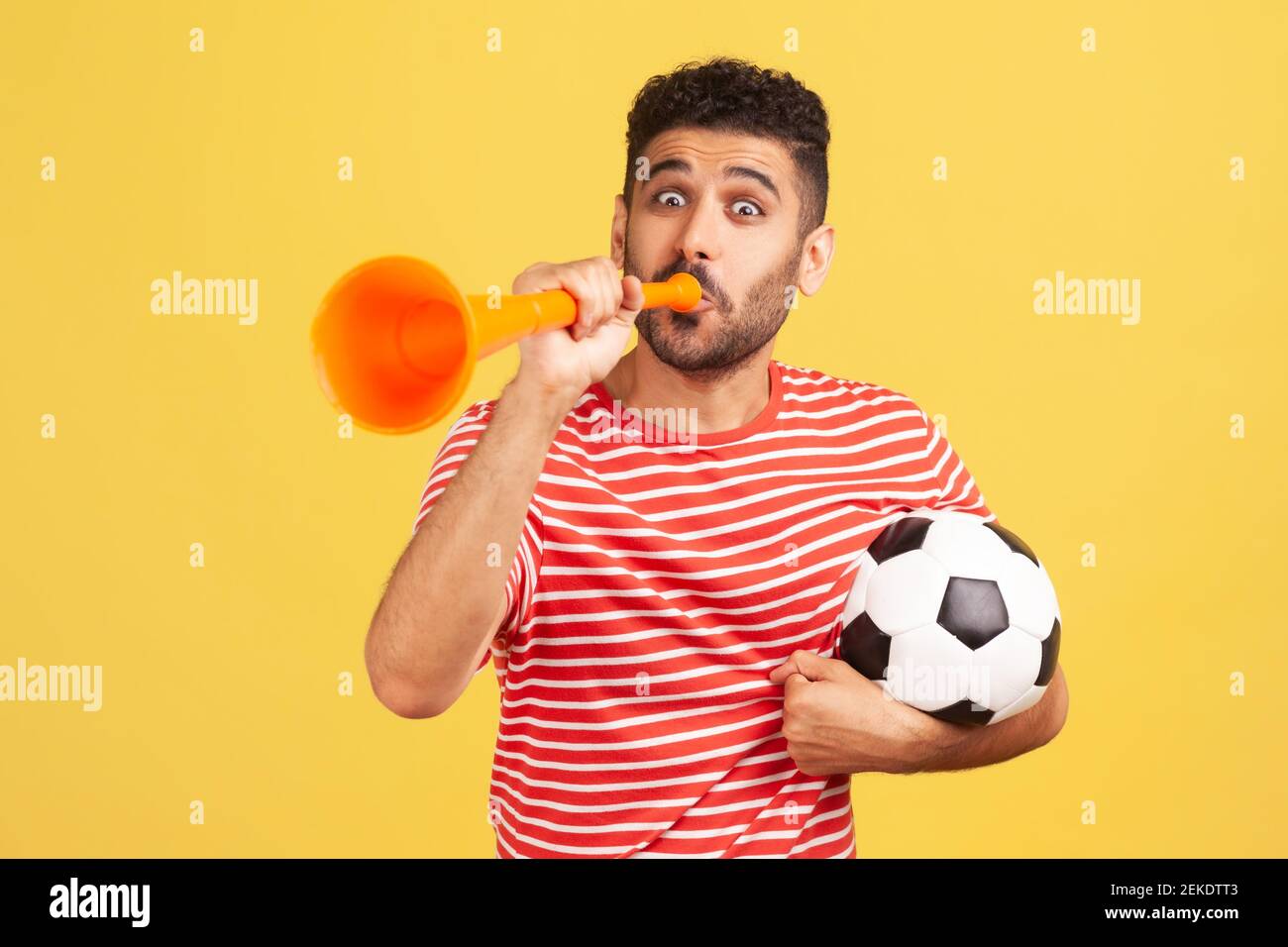 Very happy cheerful man with beard in striped t-shirt blowing in big ...