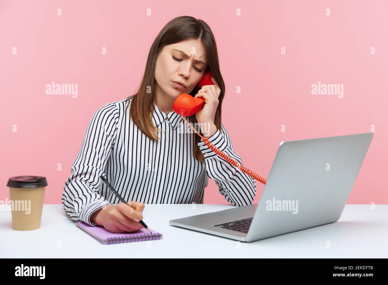 Serious concentrated brunette woman secretary answering call on ...