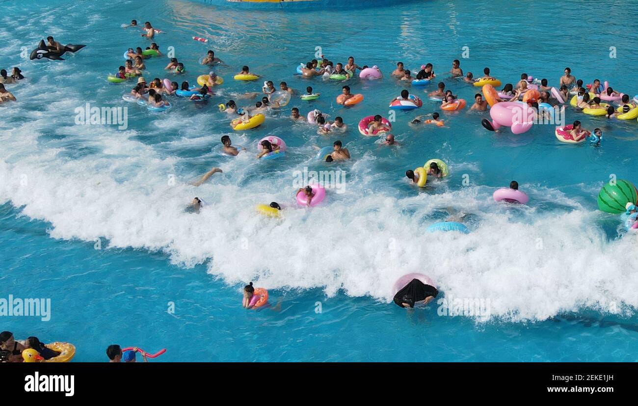 Visitors cool off by playing with water at the water park. Yangzhou ...