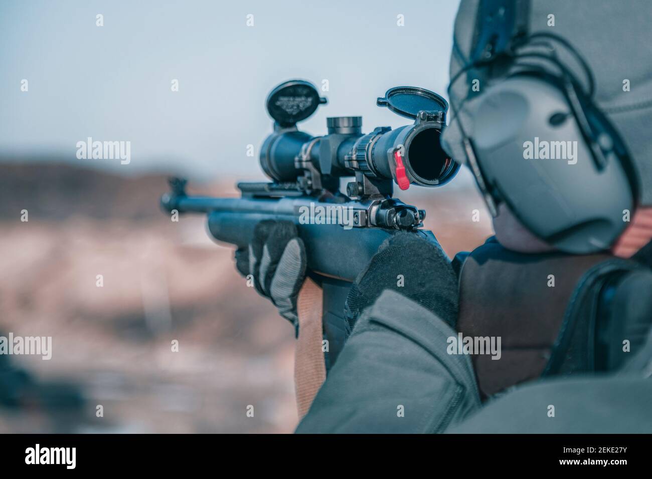 Shooter with a rifle. Man shoots a rifle, rear view, selective focus on ...