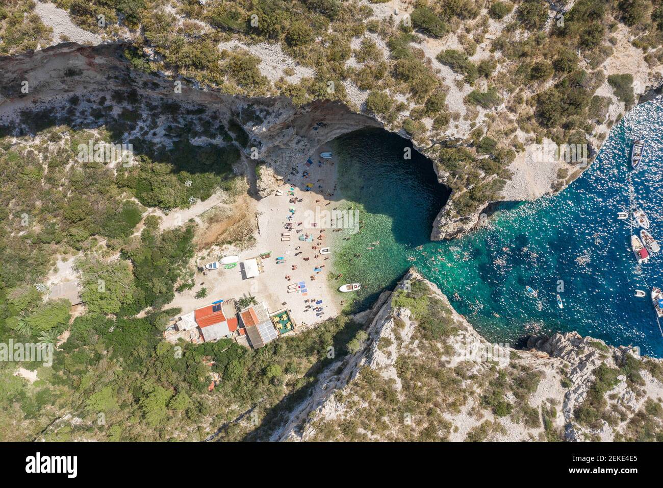 Aerial overhead drone shot of tourists swim sunbath at Stiniva beach on ...