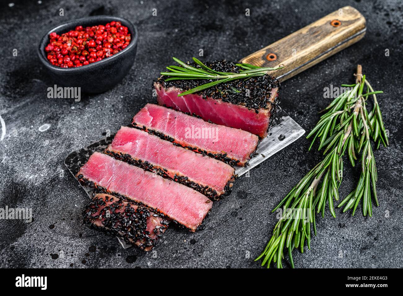 Fried fish tuna steak slices on a meat cleaver. Black background. Top ...
