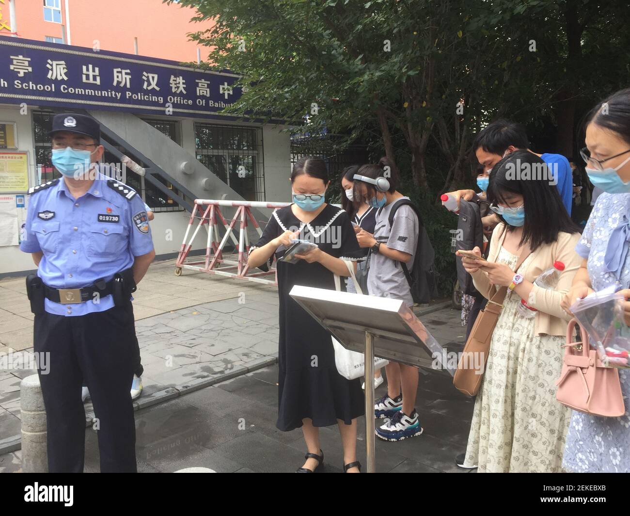 Candidates of civil servants wait outside a testing center, preparing ...