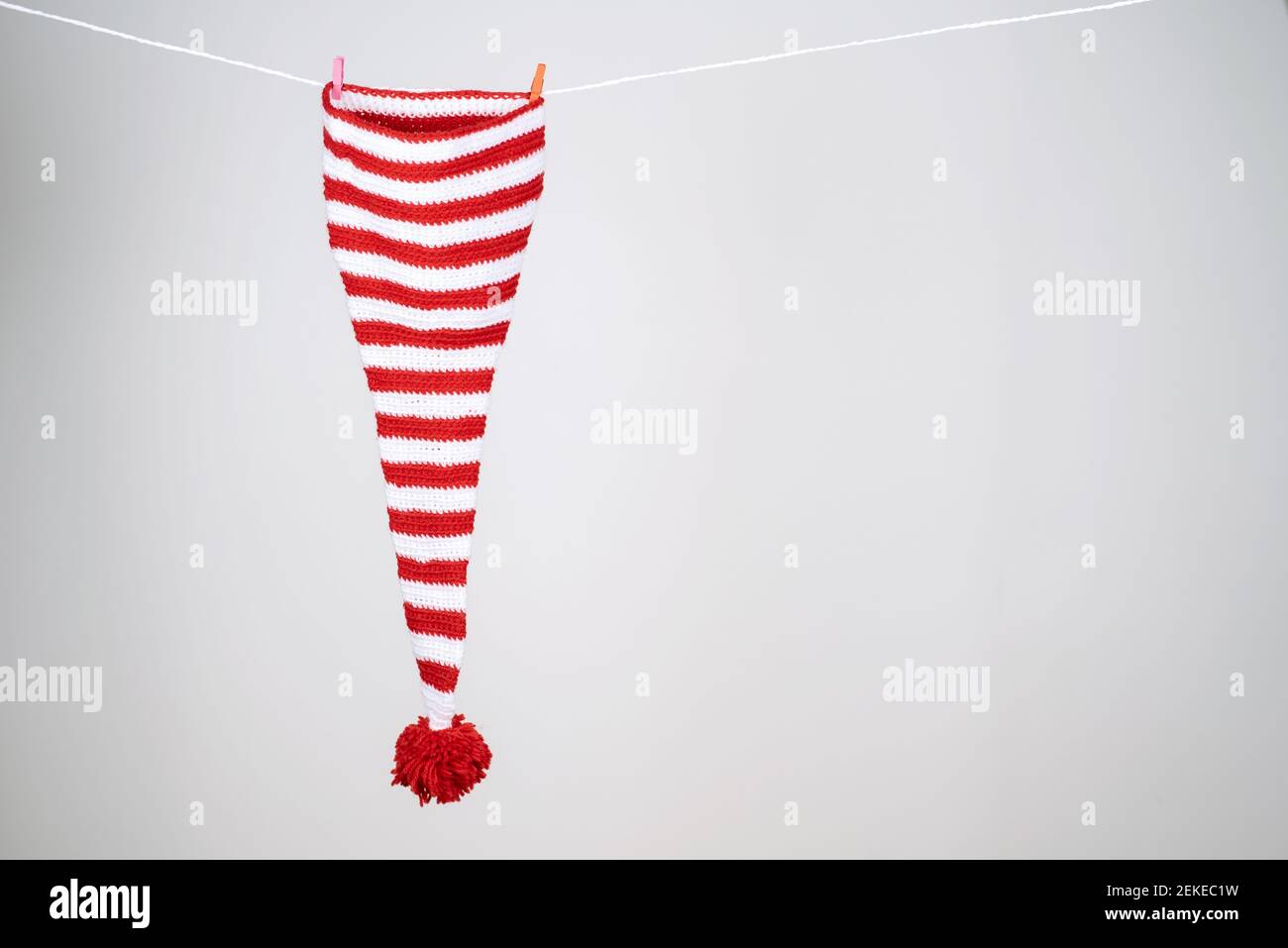 One red and white striped cap with a long tail and a large red pompom ...