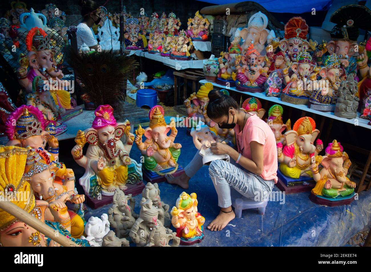 A female artist making final touches to an idol of elephant-headed ...
