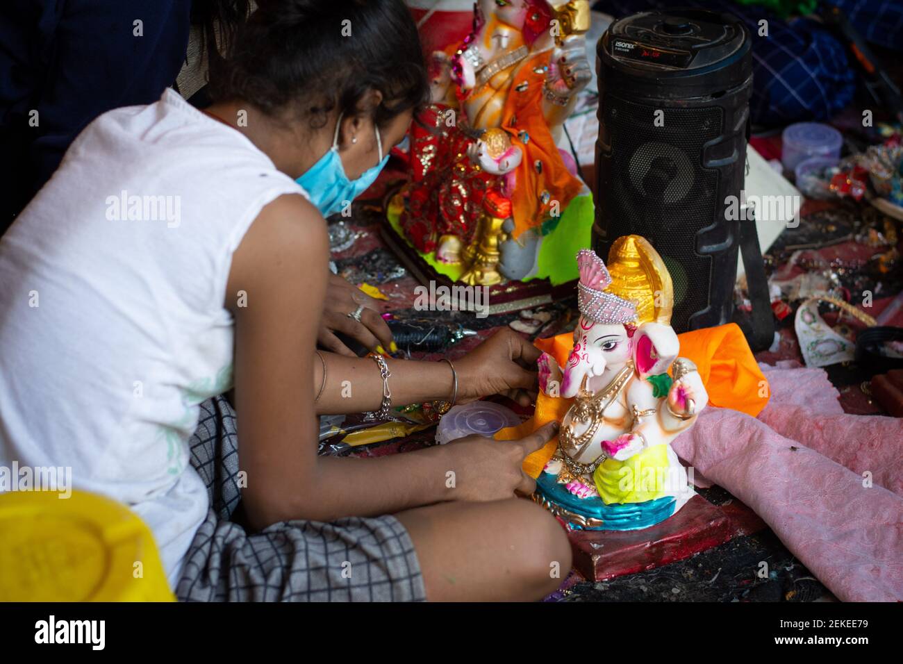 A female artist making final touches to an idol of elephant-headed ...