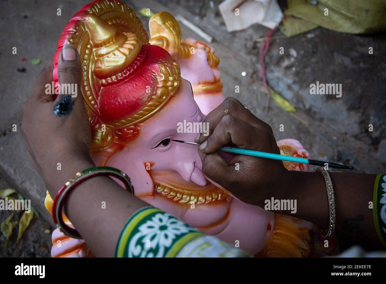 A female artist making final touches to an idol of elephant-headed ...