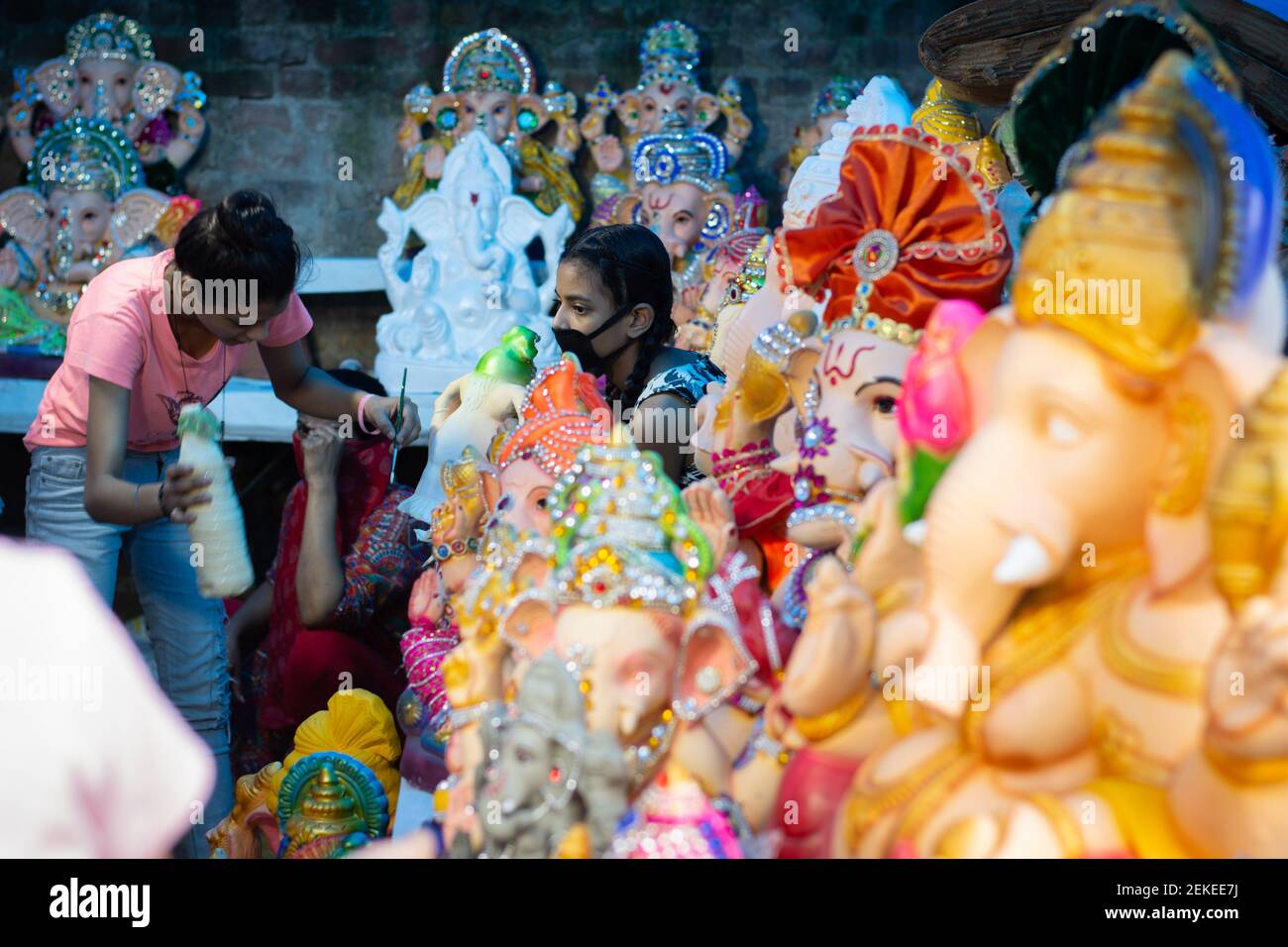 A female artist making final touches to an idol of elephant-headed ...
