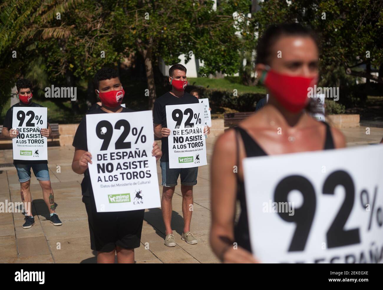 Activists wearing face masks hold placards as they take part in a ...