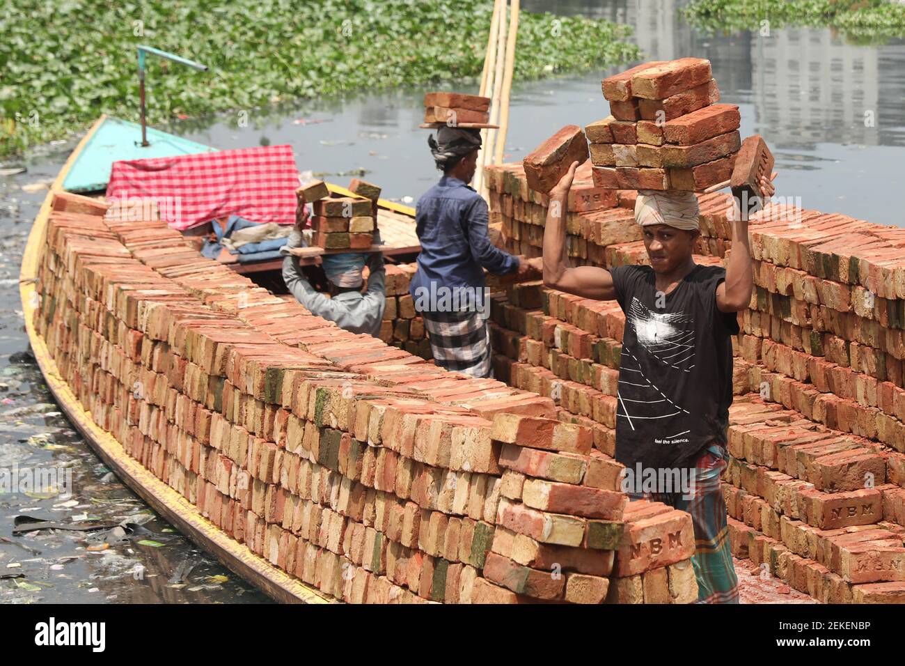 Labourers seen unloading bricks from a boat in Dhaka. (Photo by Md ...