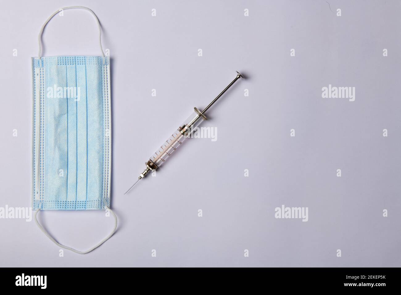 blue medical mask and syringe on white background Stock Photo - Alamy