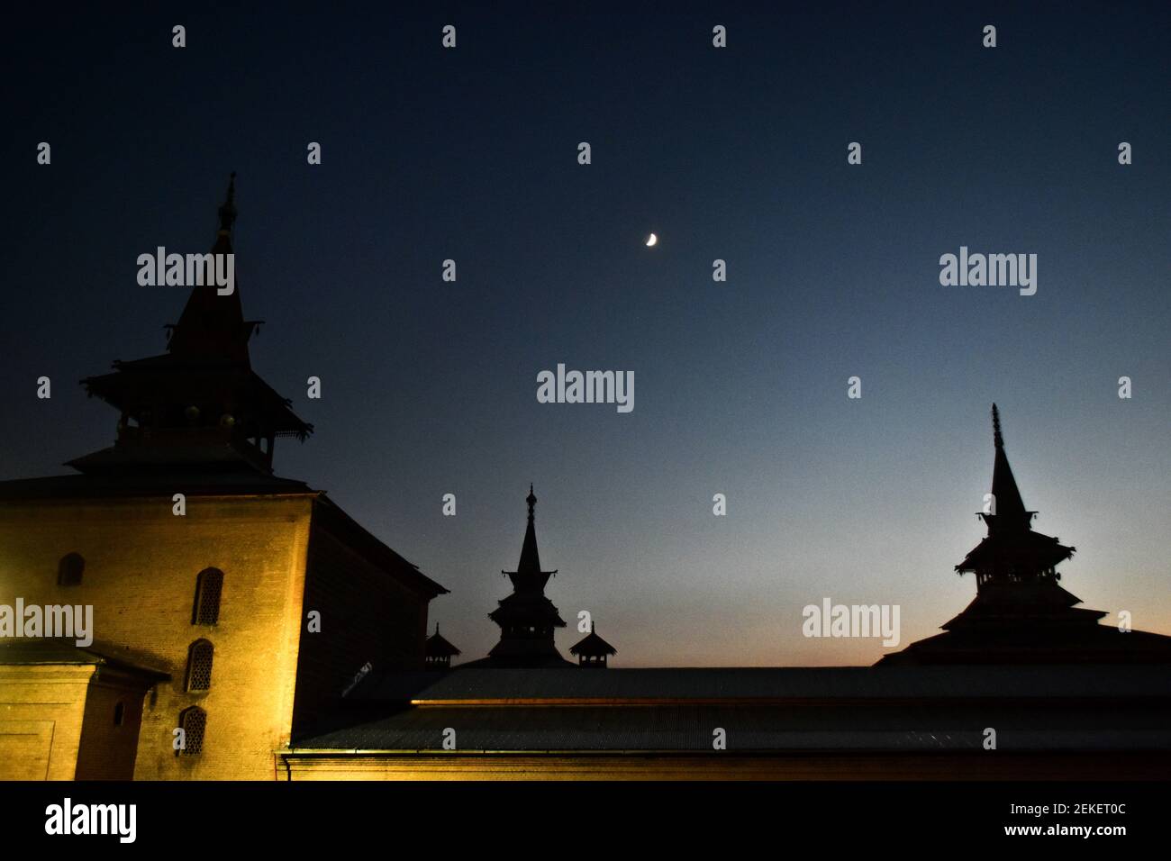 The waxing crescent moon rises over the historic Grand Mosque in ...