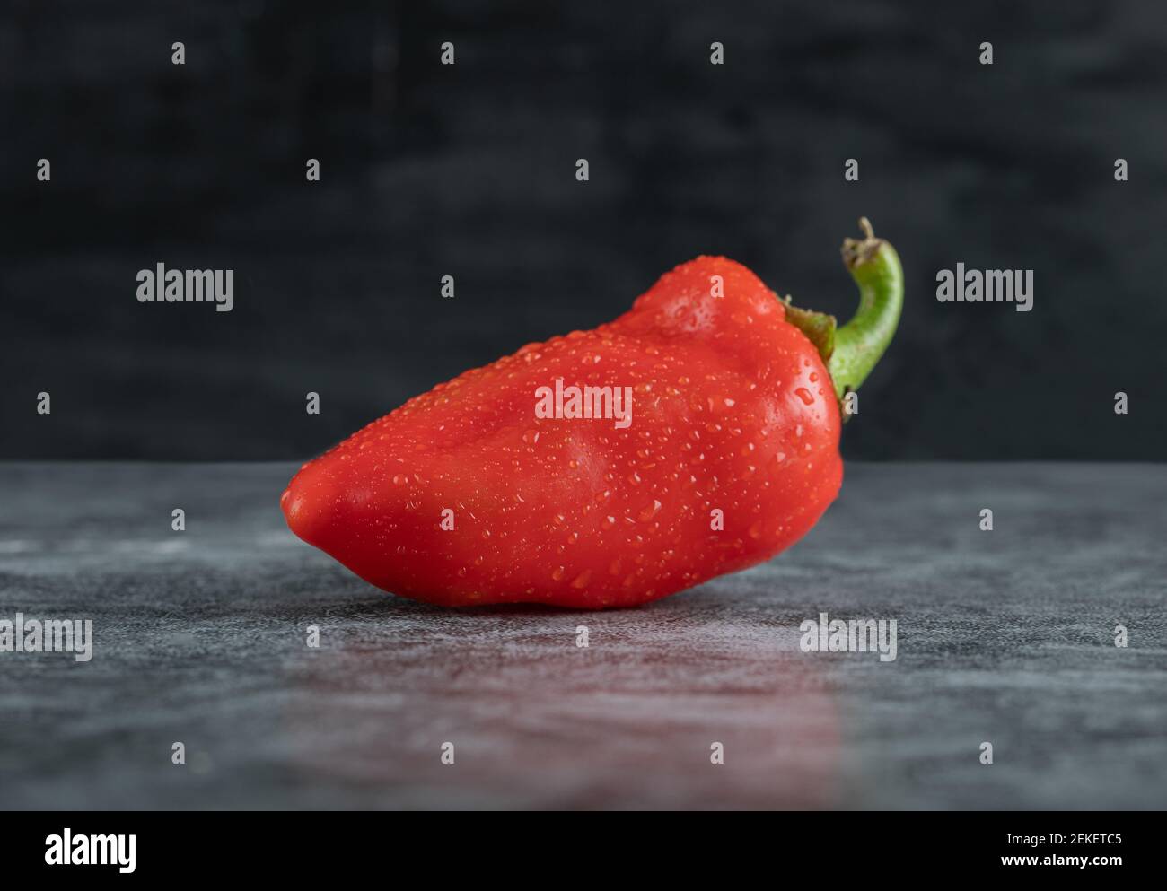 A whole fresh red pepper on a marble background Stock Photo - Alamy