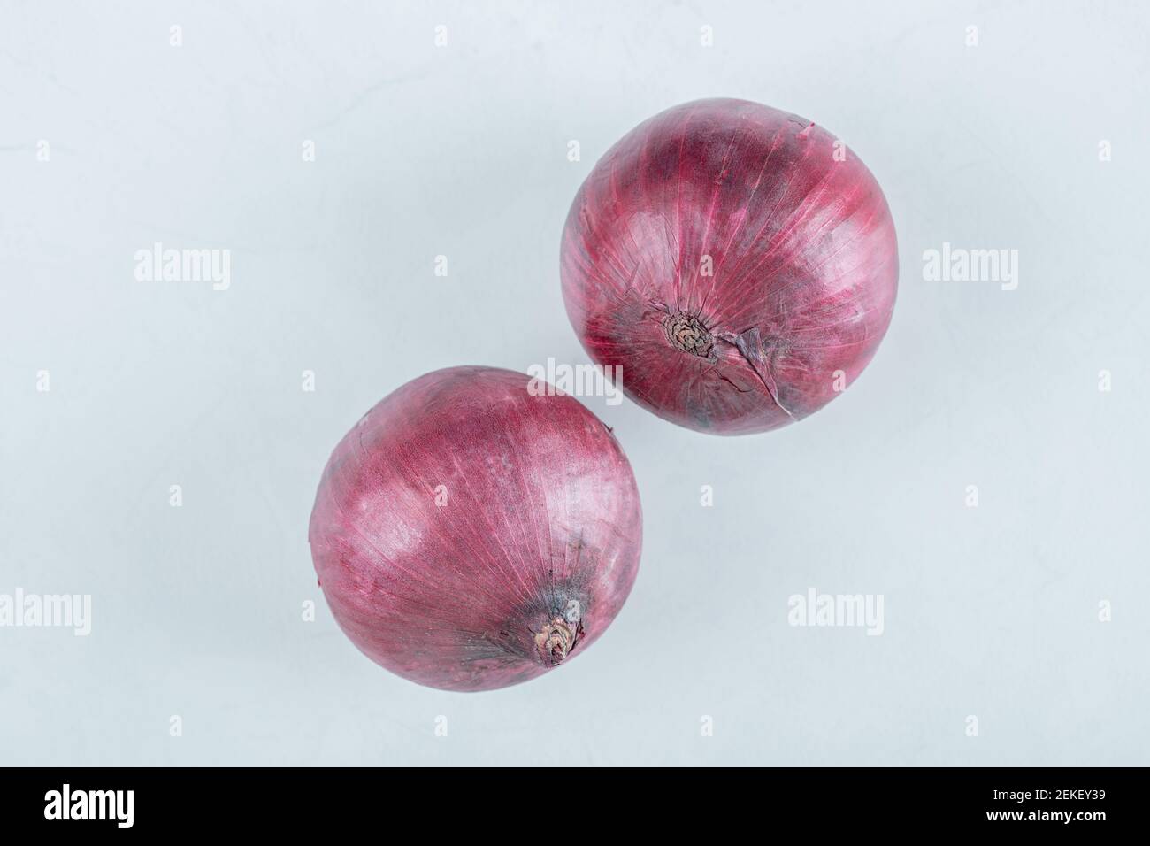 Two whole onions on white background Stock Photo - Alamy