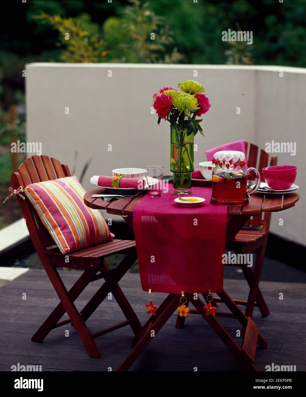 Decked area with white retaining wall, table and chairs Stock Photo - Alamy