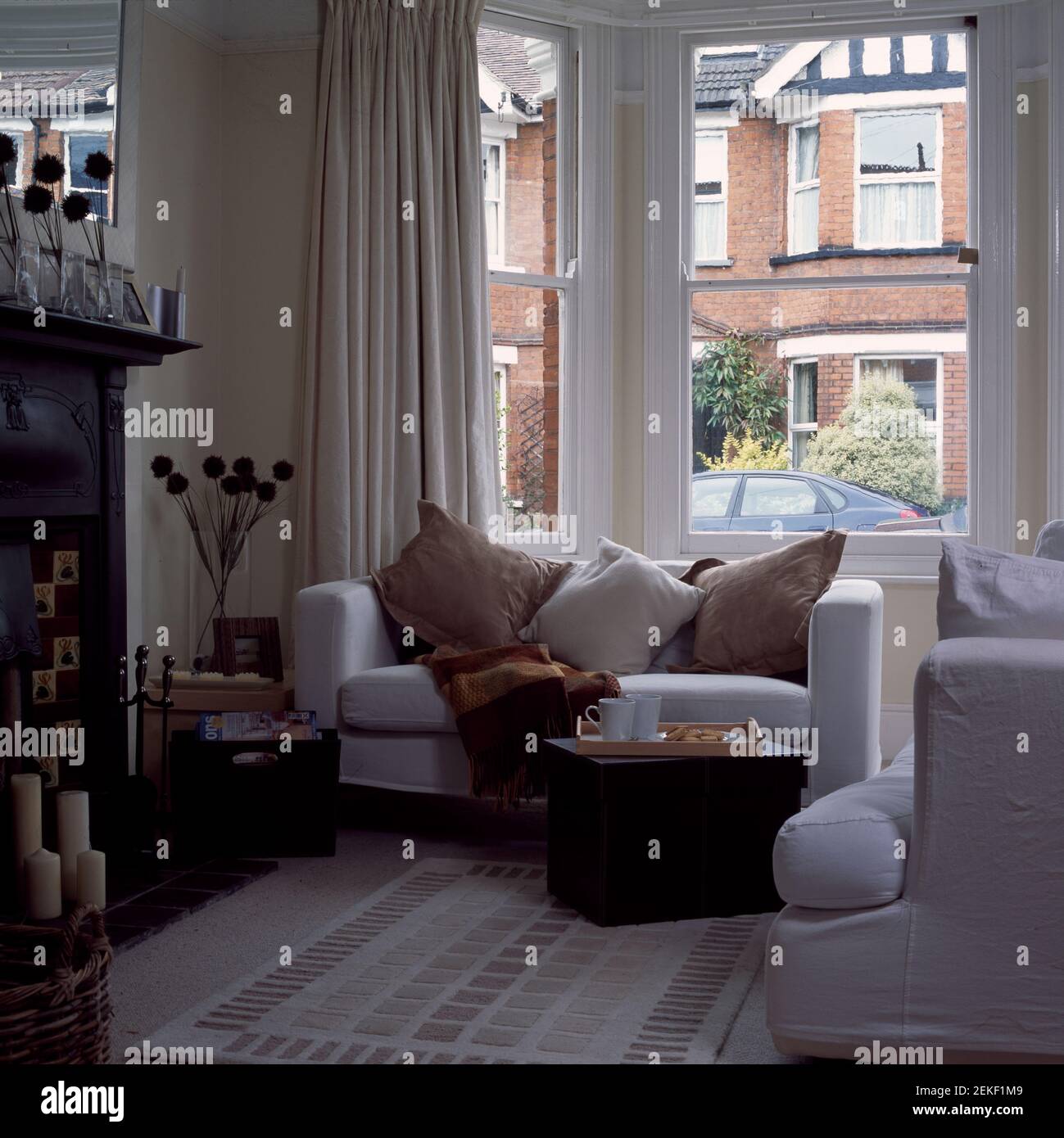 Cream coloured curtains in bay window looking onto the street Stock ...