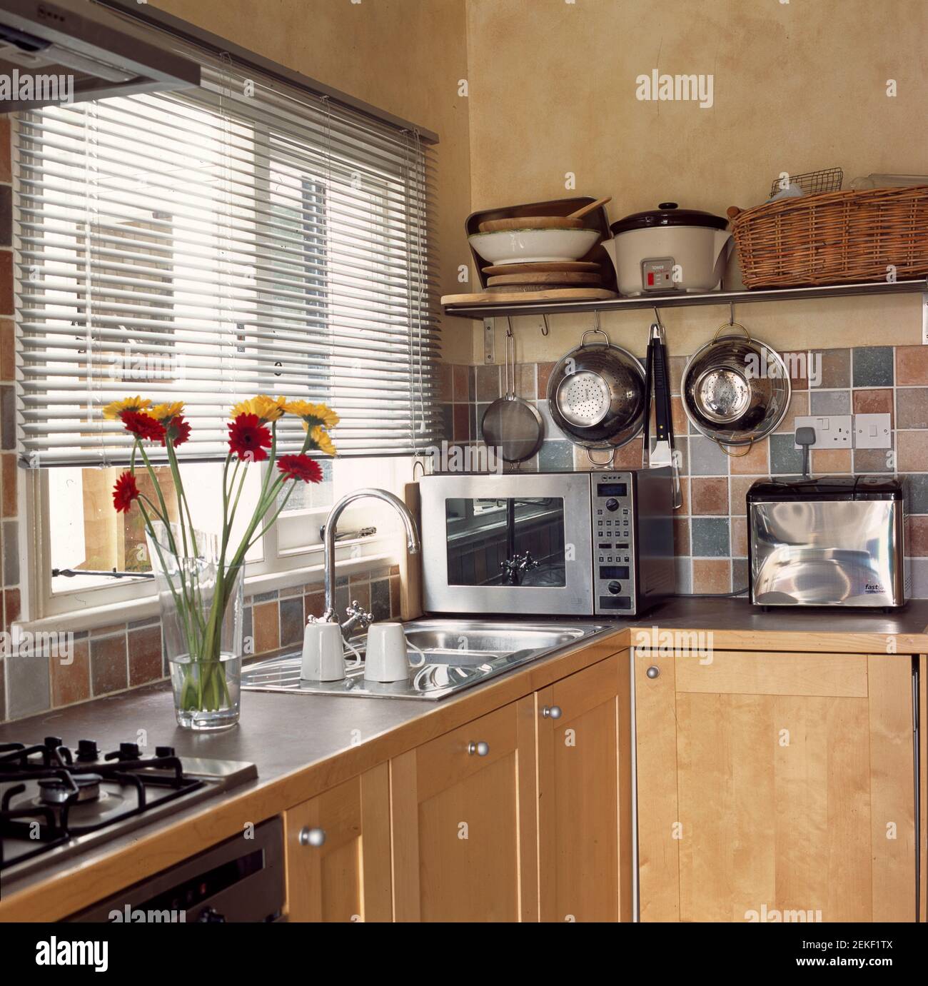 Corner os small modern kitchen with microwave on counter and venetian ...