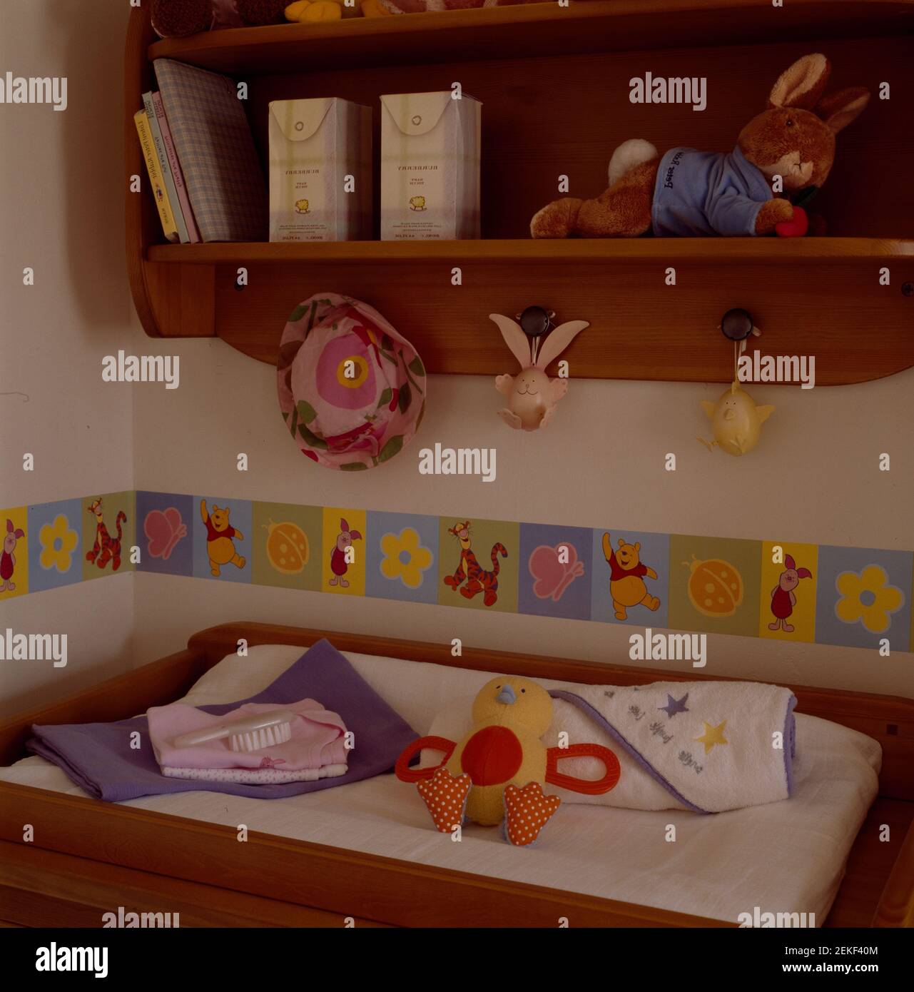 Corner of children's bedroom with baby changing mat and wallpaper ...