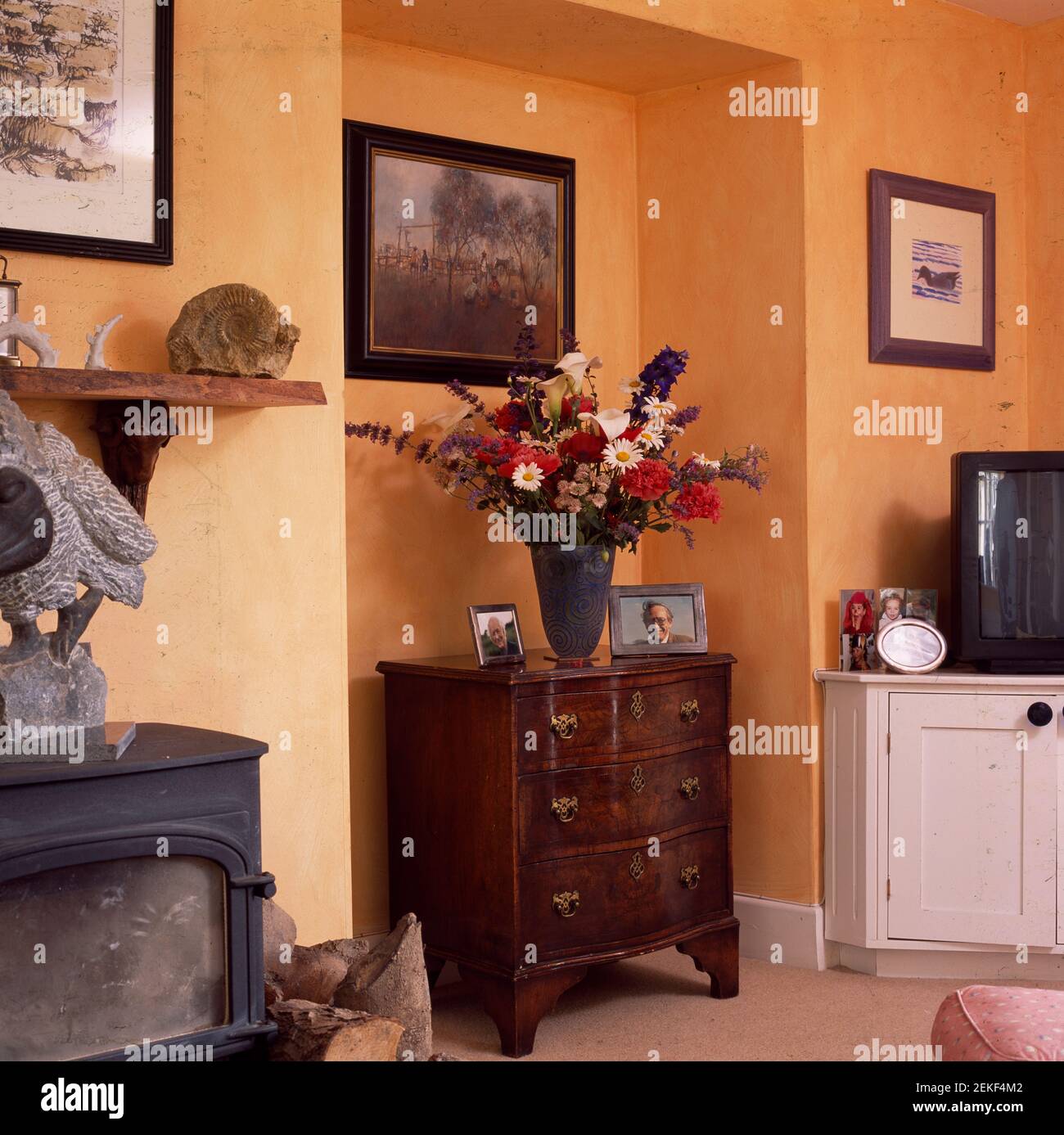 Alcove with picture and dark wooden chest, picture and vase of mixed ...